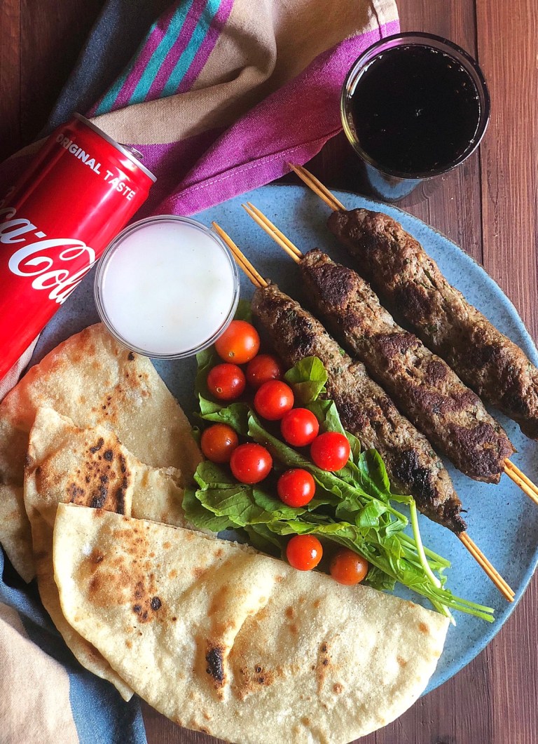 A grilled kofta sandwich with tahini or tzatziki, some pickles & french ...